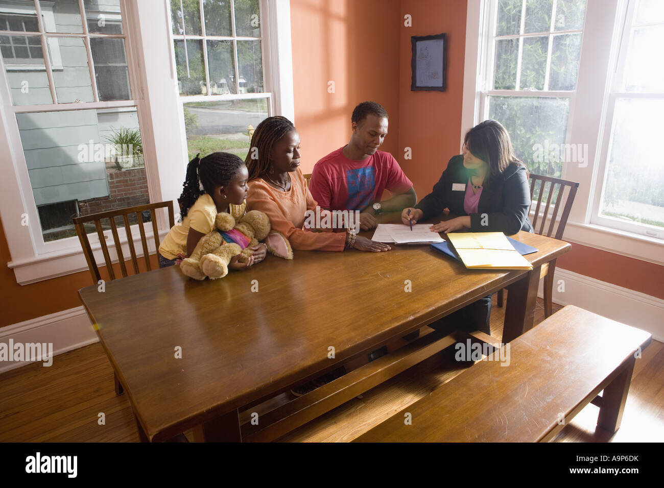 Family at home signing papers with agent Stock Photo - Alamy