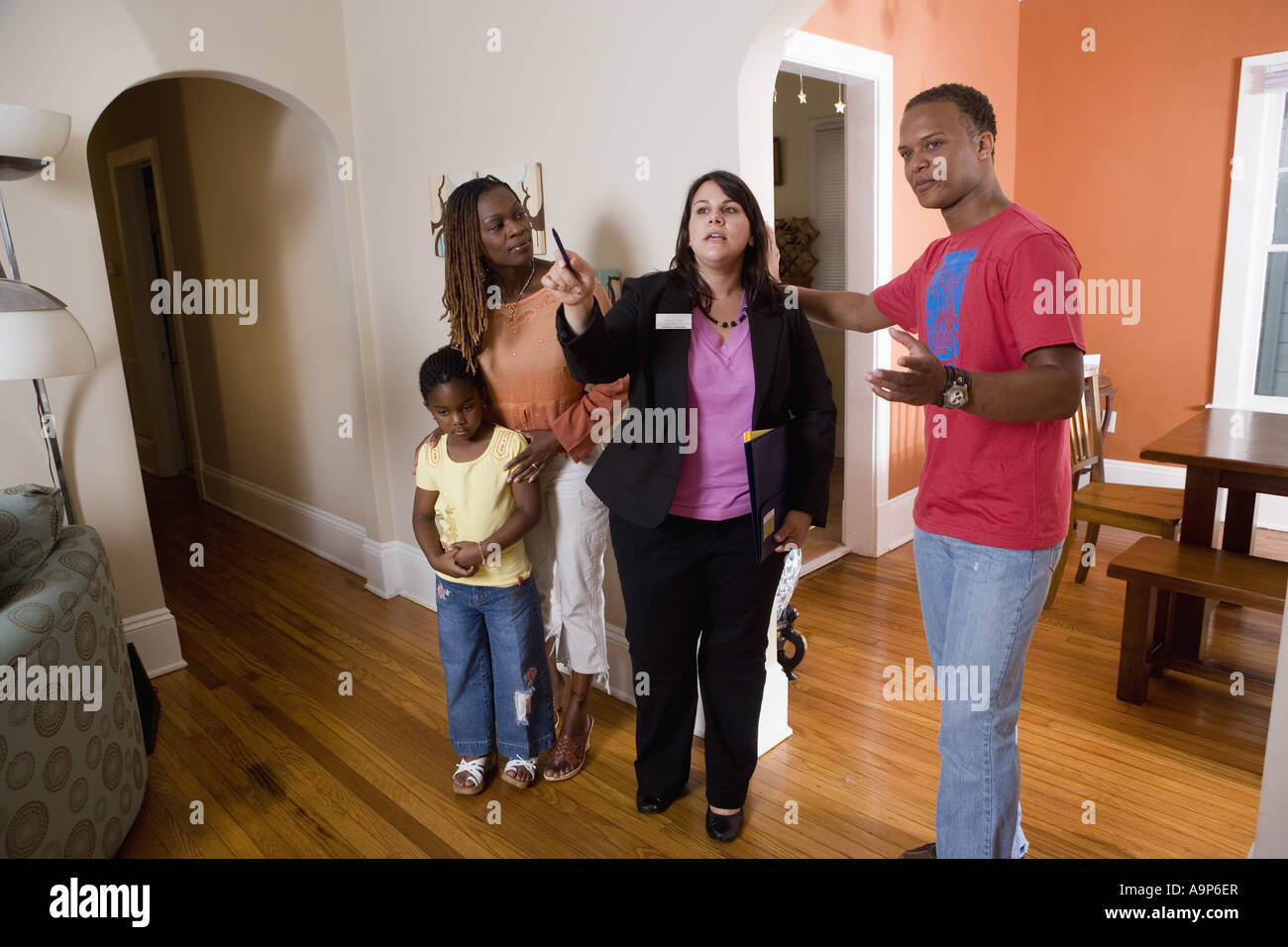 Real estate broker showing house to buyers Stock Photo - Alamy