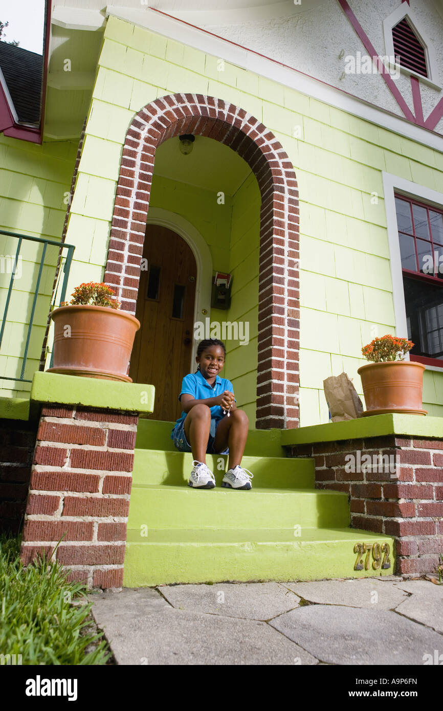 Portrait of a girl sitting on front steps of house Stock Photo - Alamy