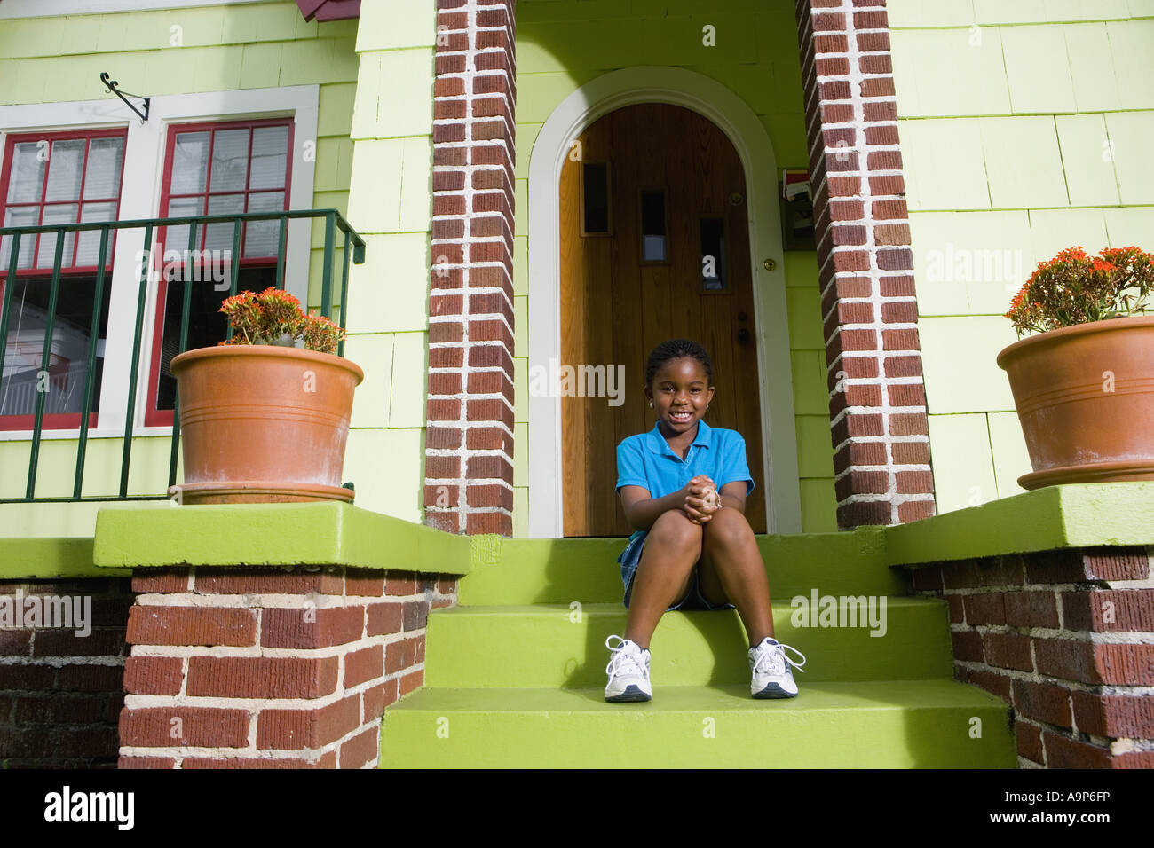 Portrait of a girl sitting on front steps of house Stock Photo - Alamy