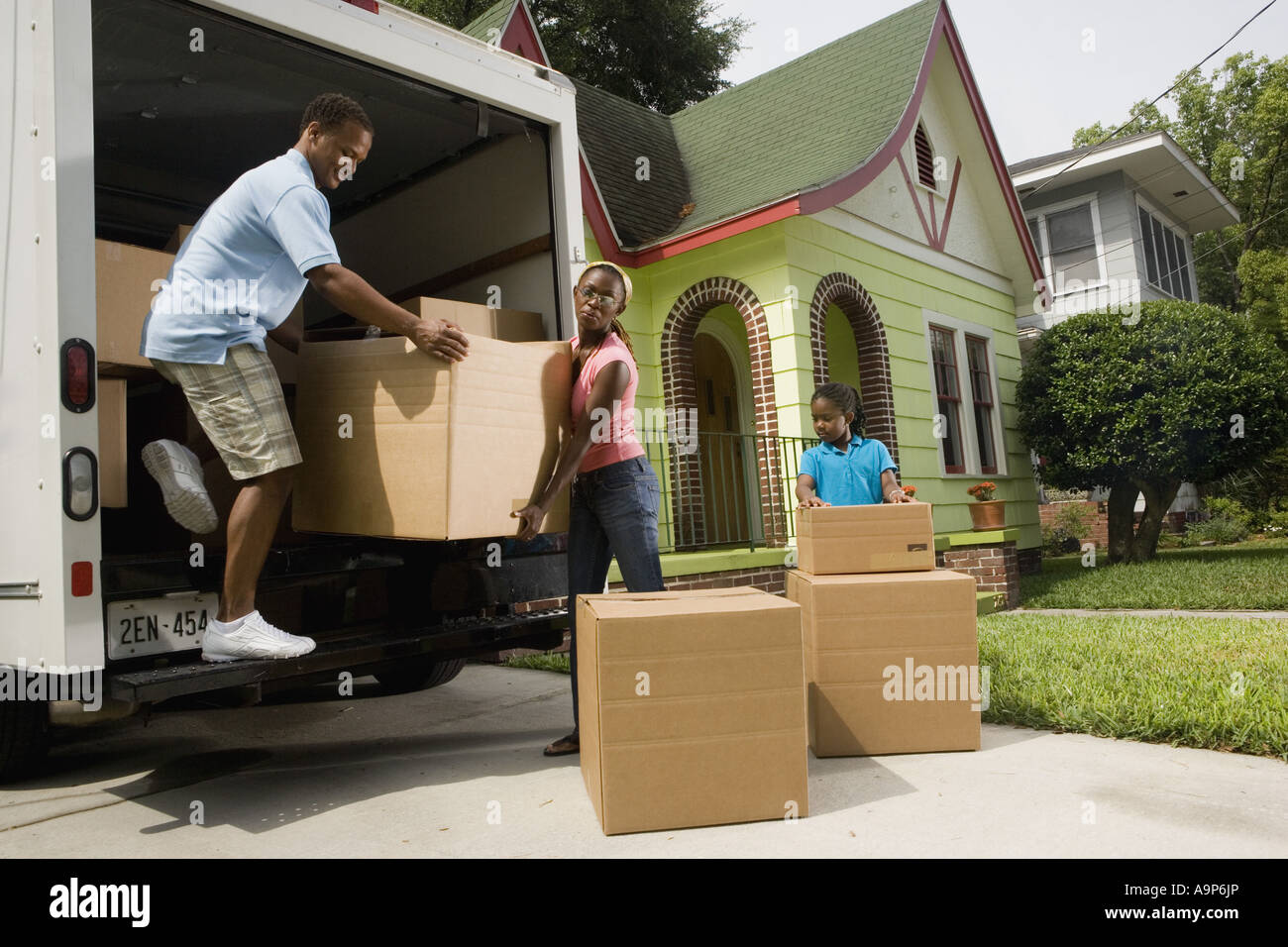 Family unloading boxes from moving truck Stock Photo - Alamy