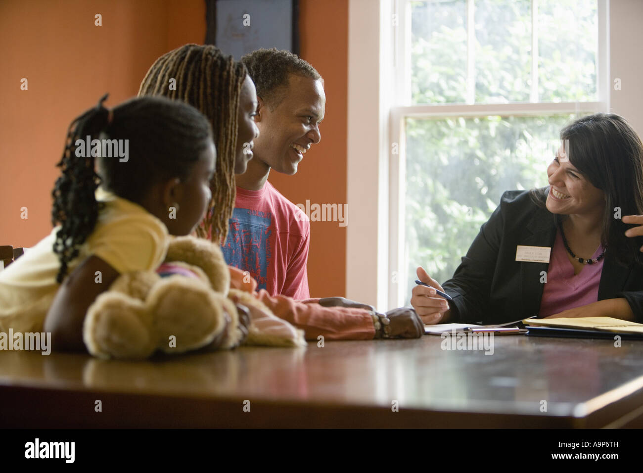 Family at home signing papers with agent Stock Photo - Alamy
