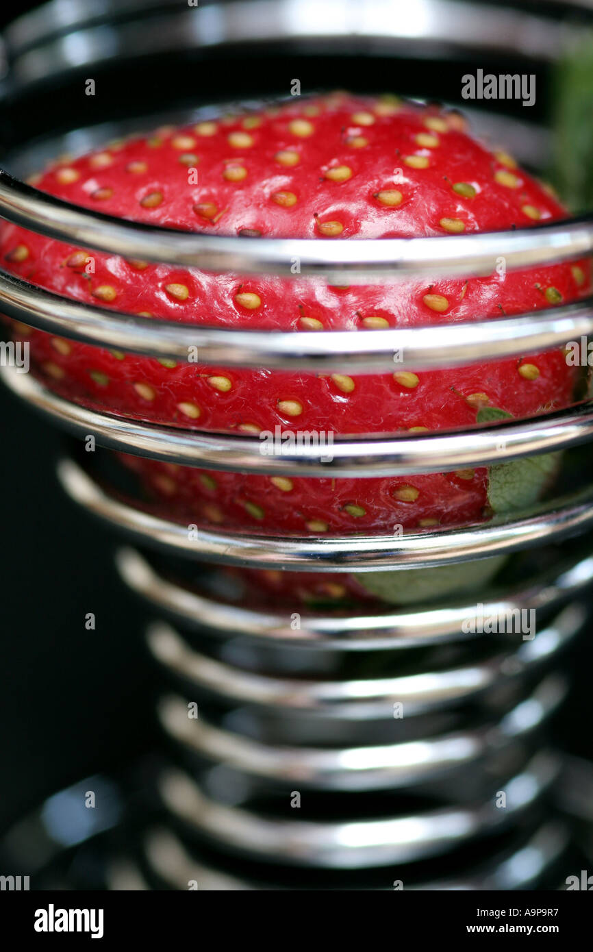 Strawberry in a stainless steel wire cup against black background Stock ...