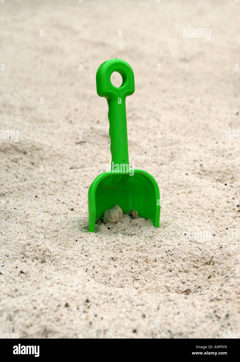Green plastic spade in sand. UK Stock Photo - Alamy