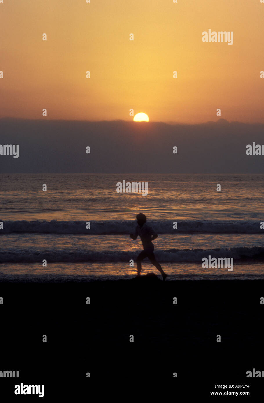 Male running on beach sunset hi-res stock photography and images - Alamy