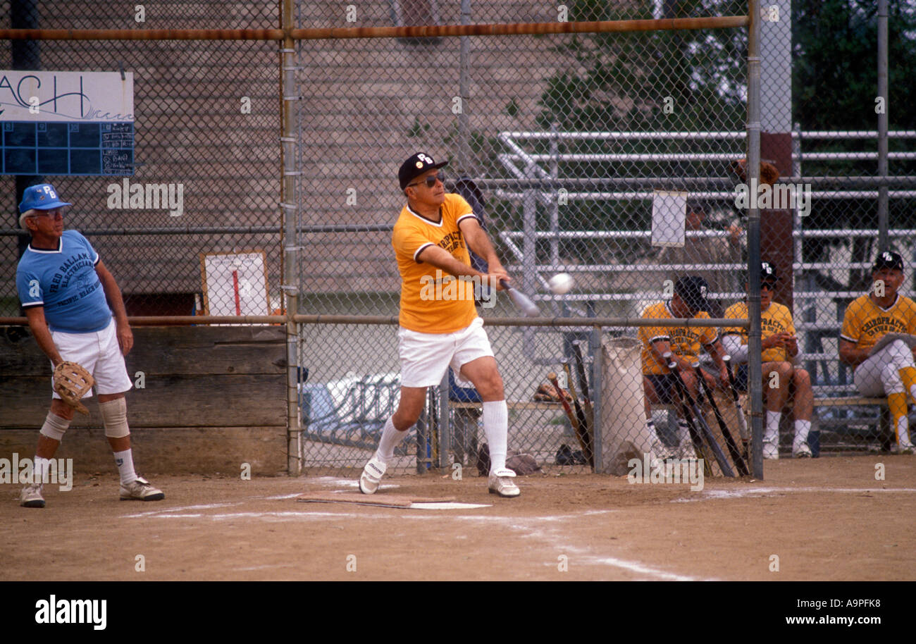 Senior softball player batting during game Stock Photo - Alamy