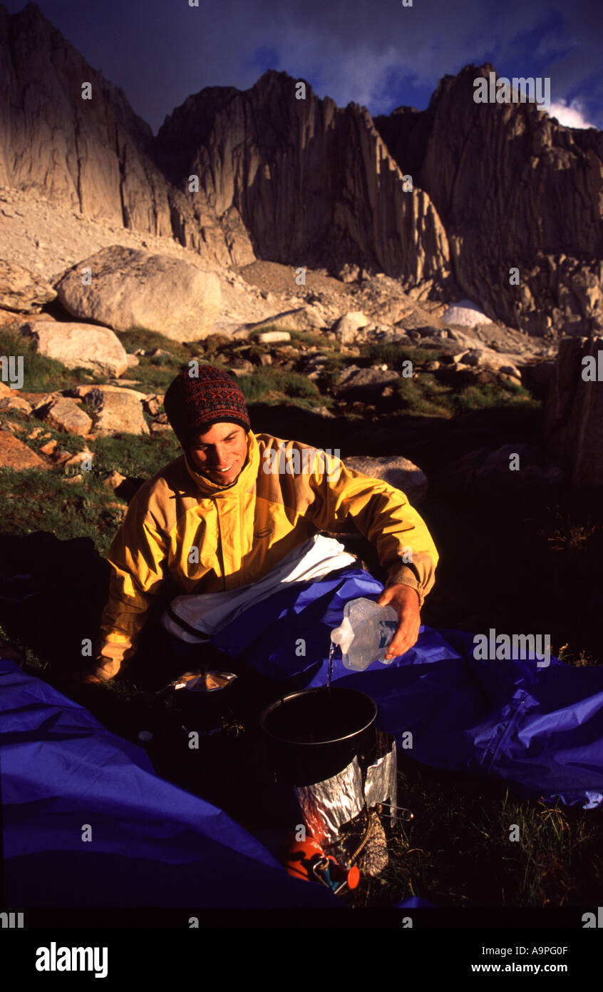 A man cooking a meal in camp while on a hiking trip in the Sierra ...