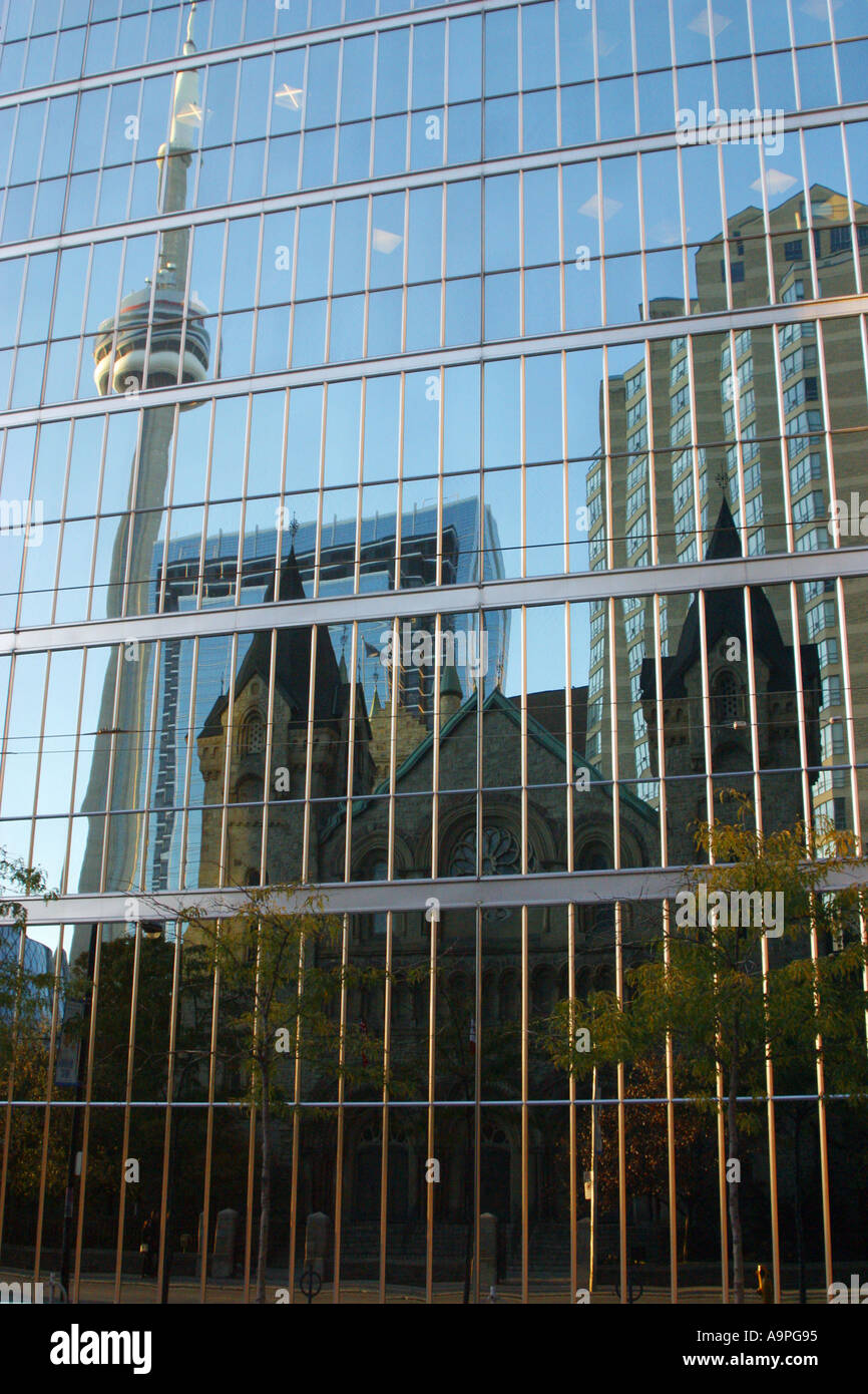 CN tower and church reflected in window glass of modern office building ...
