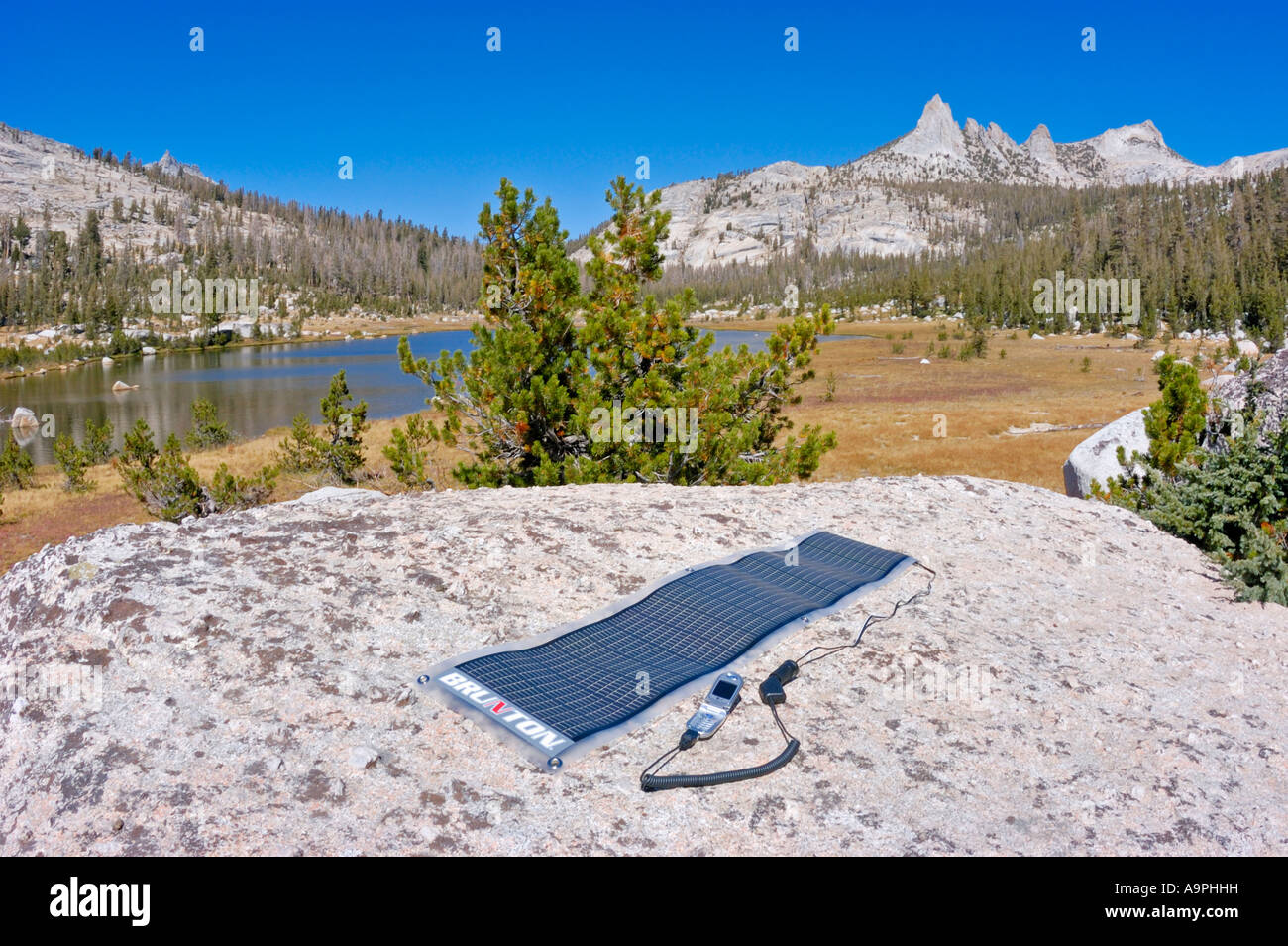 Solar panel charging a cell phone on a boulder Echo Lake Yosemite ...