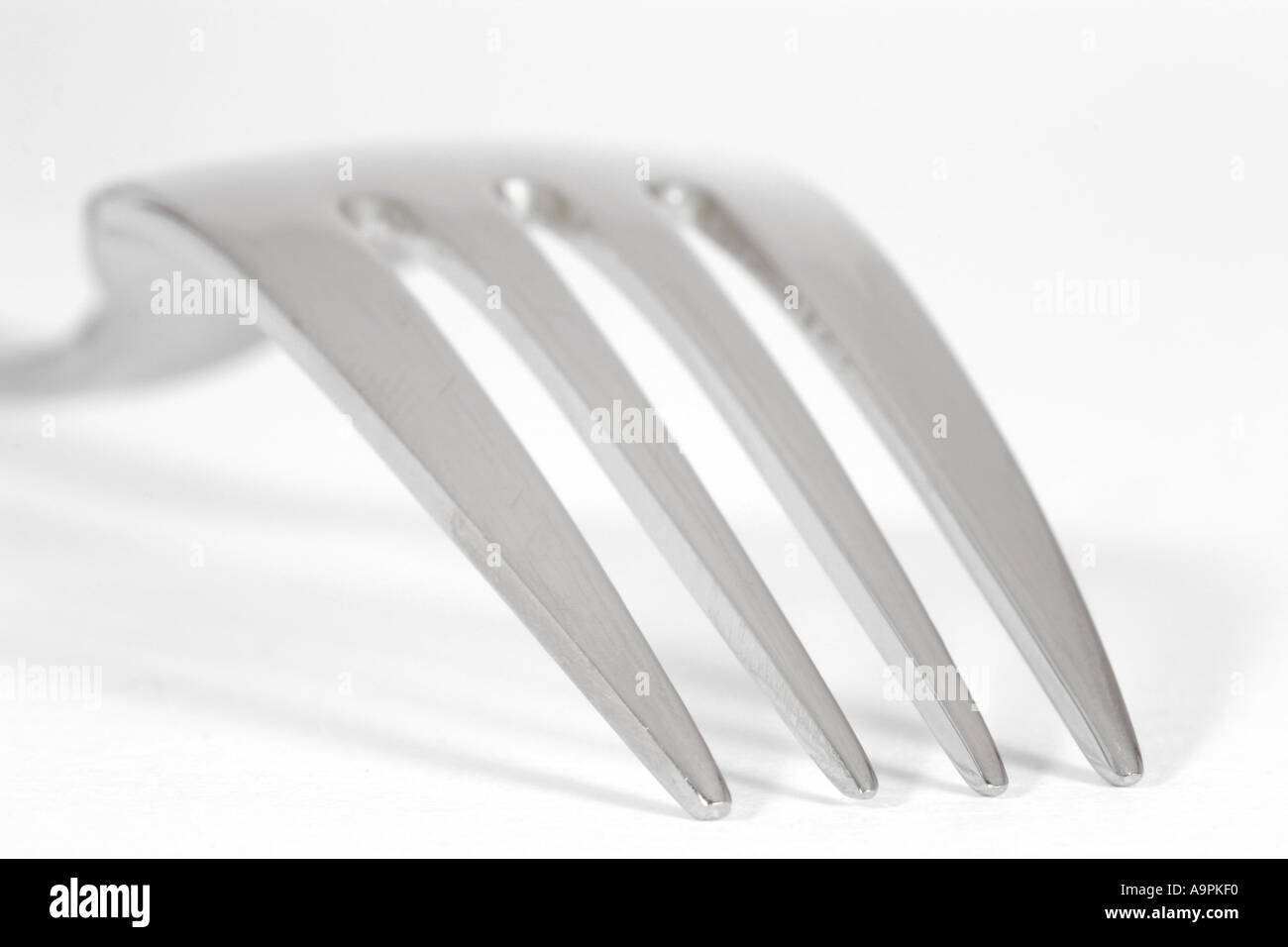 Silver fork lying on the strikes in front of white background Stock ...