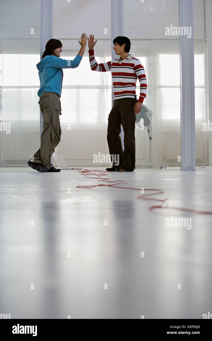 Colleagues doing a high five Stock Photo - Alamy