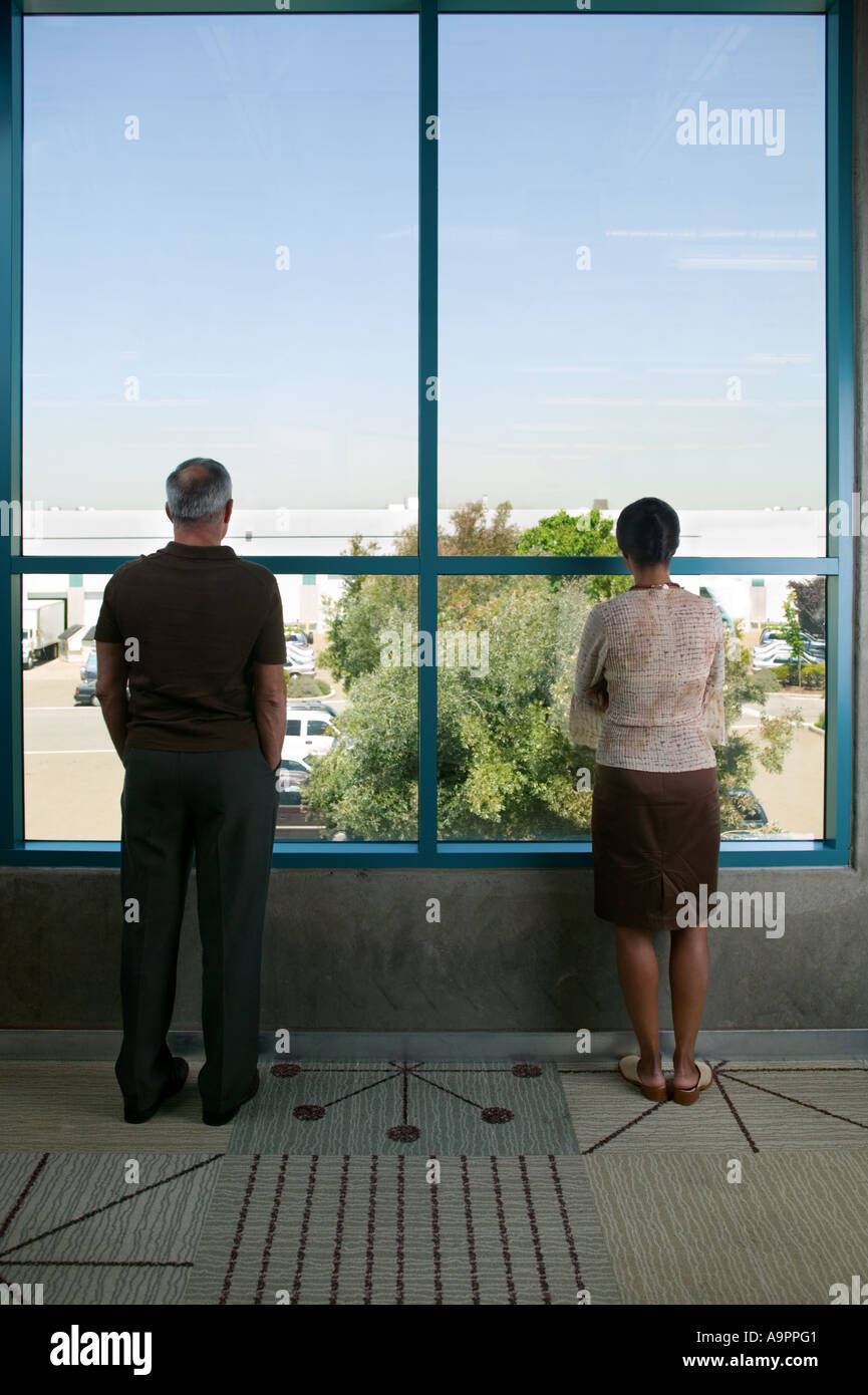 Office workers looking out of window Stock Photo - Alamy