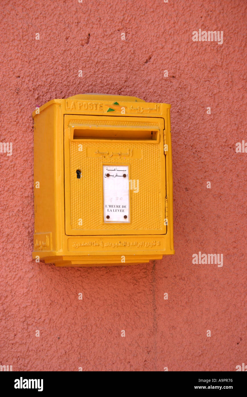 Yellow post box on pink wall Stock Photo - Alamy