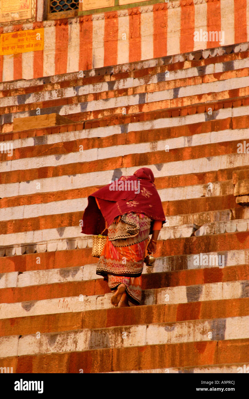 Woman ascending Ghat steps, banks of the Ganges River, Varanasi, India ...