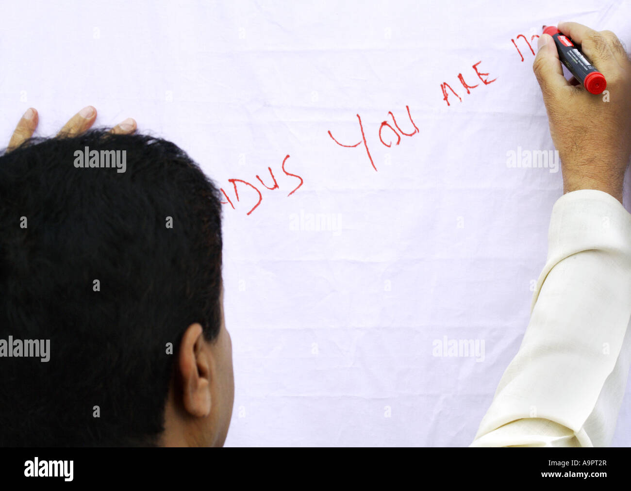 Rear view of a person writing on poster Stock Photo - Alamy