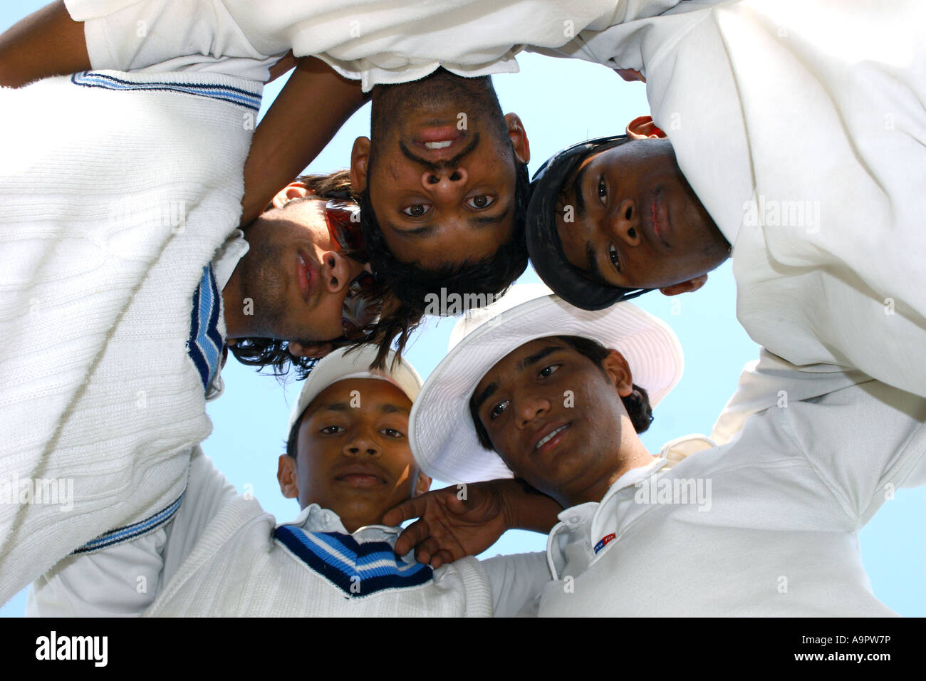 Cricketers in a huddle looking down at the camera Stock Photo - Alamy