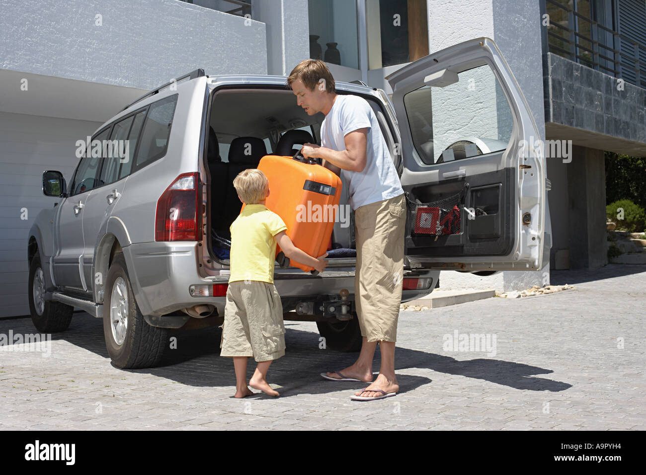 Son helping his father pack the car Stock Photo - Alamy