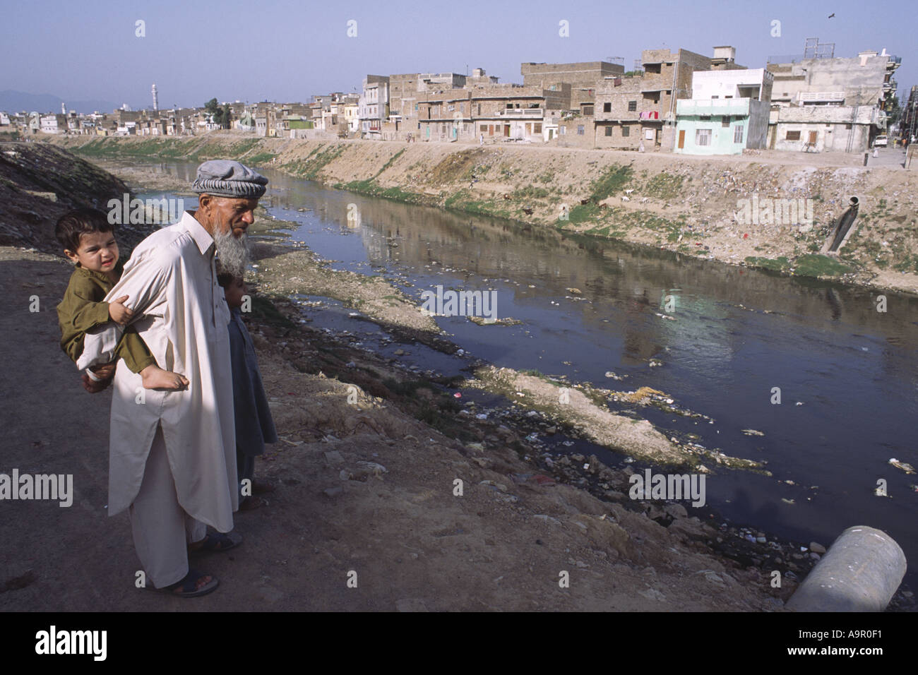 A Pakistani man with his grandsons in the urban slum of Dhok Matkial in ...