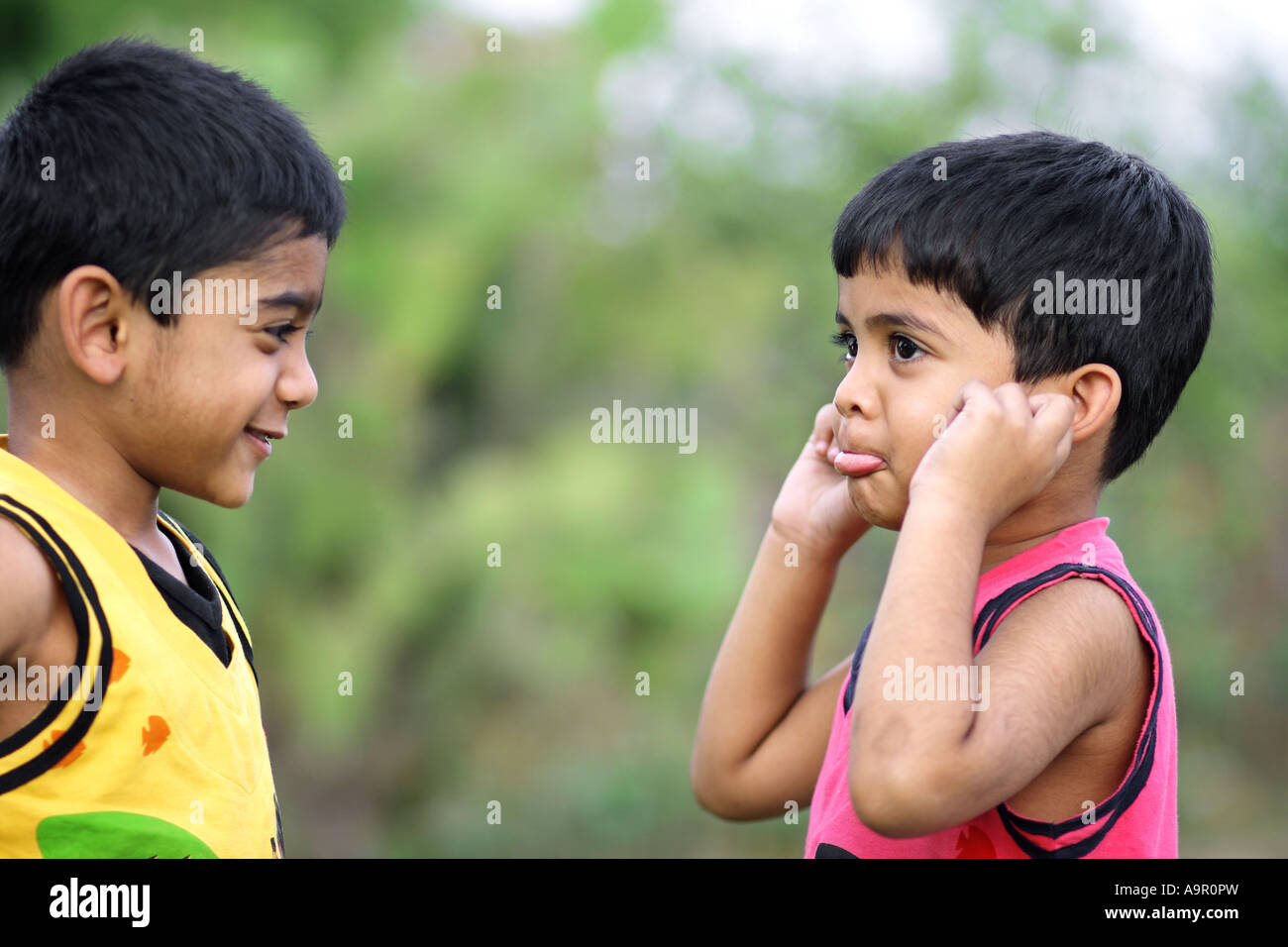 Two young kids facing each other Stock Photo - Alamy
