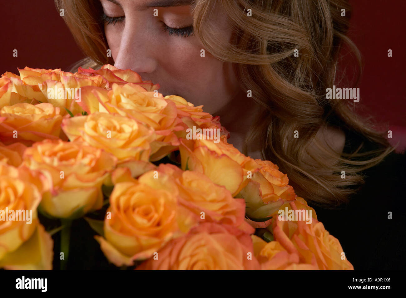 Woman smelling bunch of roses Stock Photo - Alamy
