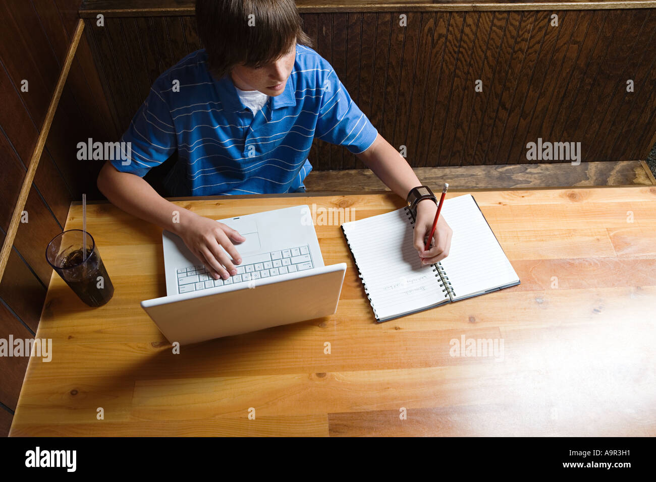Teenage boy in cafe doing homework Stock Photo - Alamy