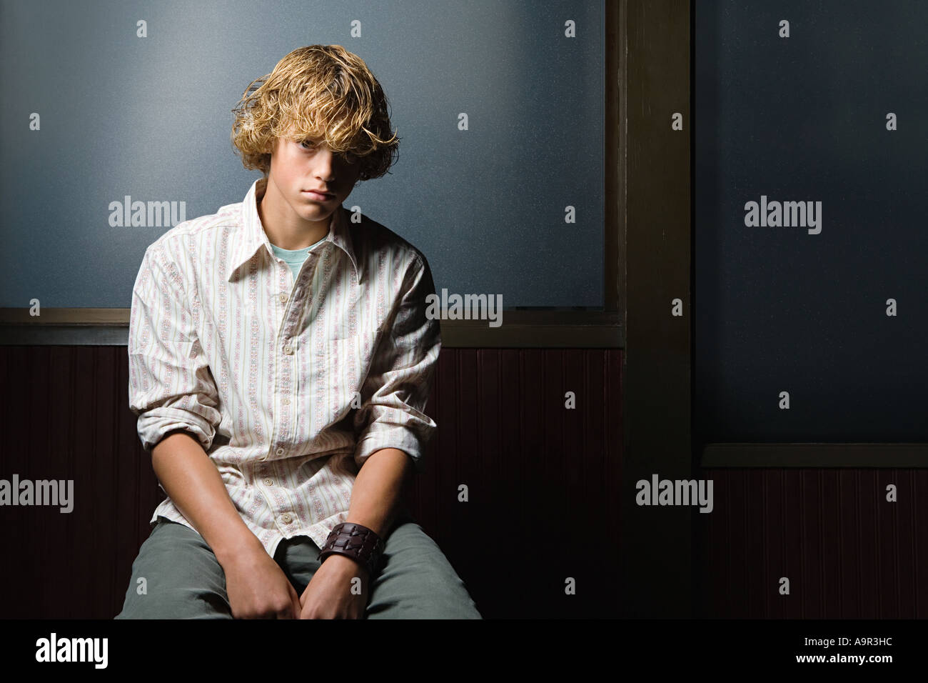 Teenage boy sat alone Stock Photo - Alamy