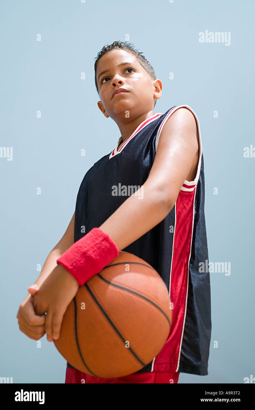 Boy in basketball uniform holding basketball Stock Photo - Alamy