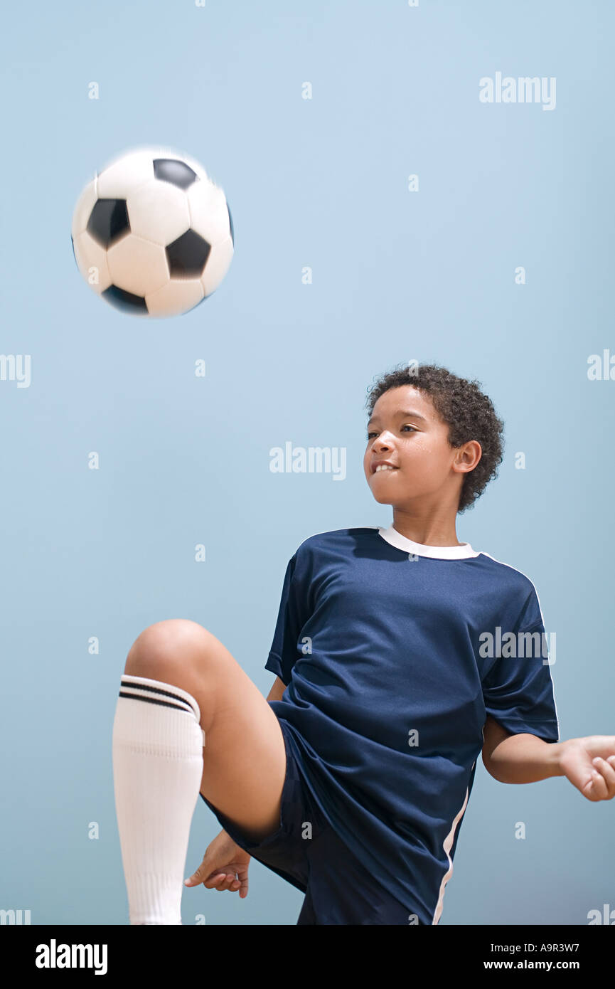 Boy playing keepy uppy with football Stock Photo - Alamy