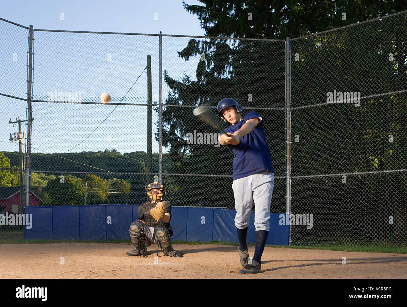 Teenage boy swinging to hit baseball Stock Photo - Alamy