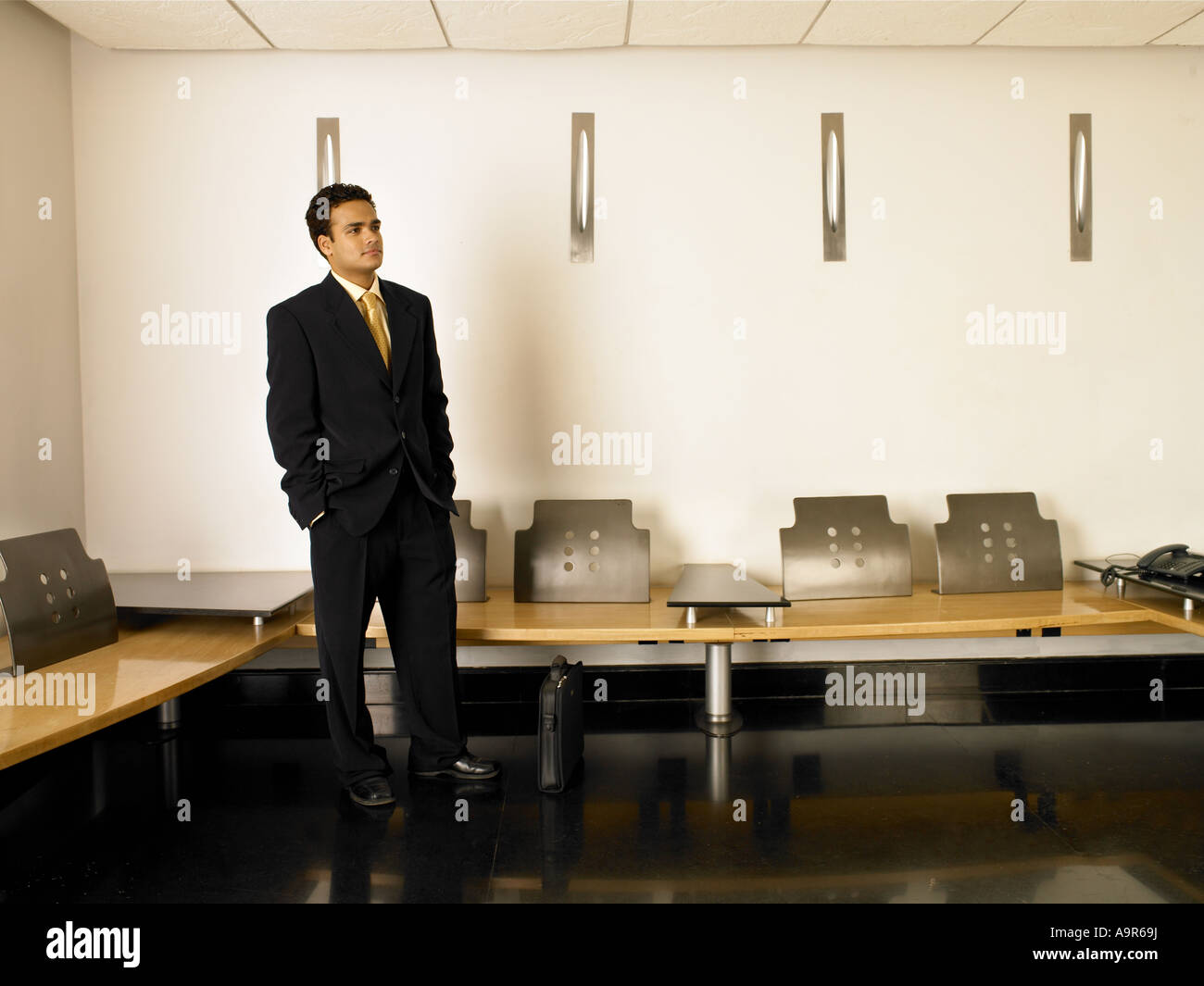 A man in formal clothes waiting in an office lobby Stock Photo - Alamy