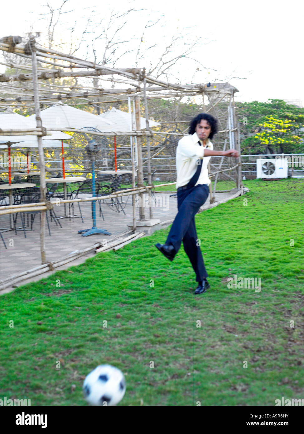 A young professional kicking a football Stock Photo - Alamy