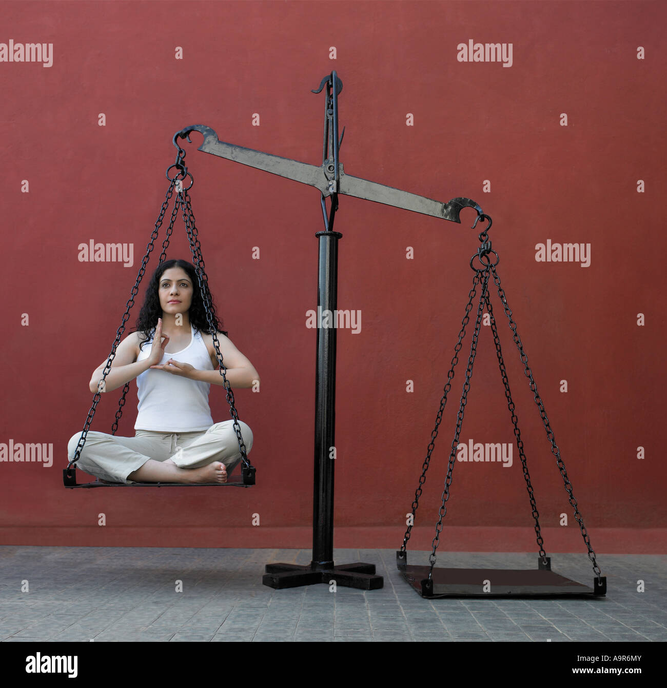 A woman sitting and doing yoga on a weighting scale Stock Photo - Alamy