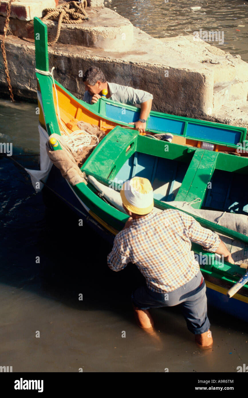 Hauling out a kajjikk class inshore fishing boat St Julian s Bay Malta ...