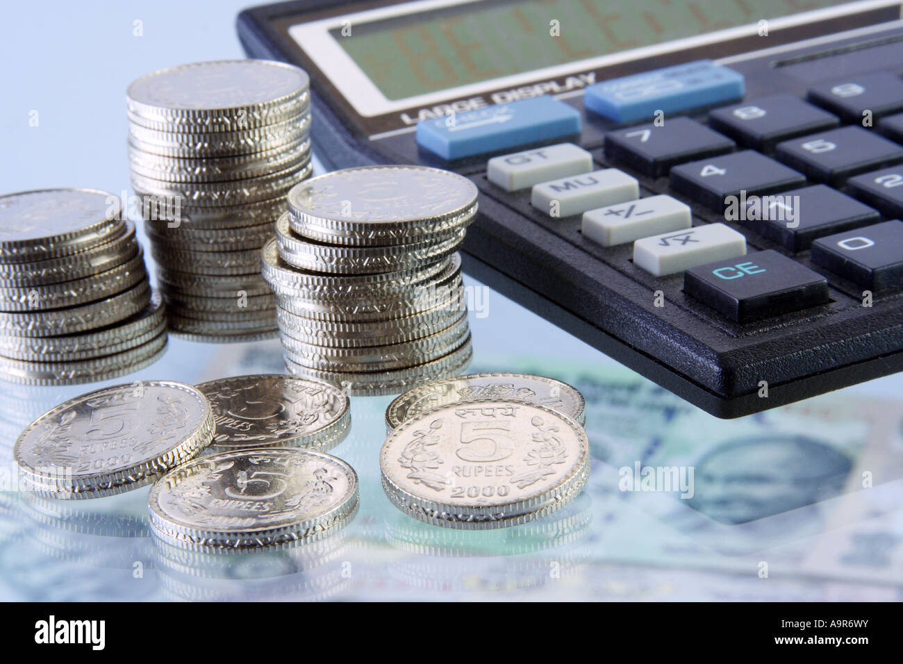 Stack of Five Rupees coins beside a calculator Stock Photo - Alamy