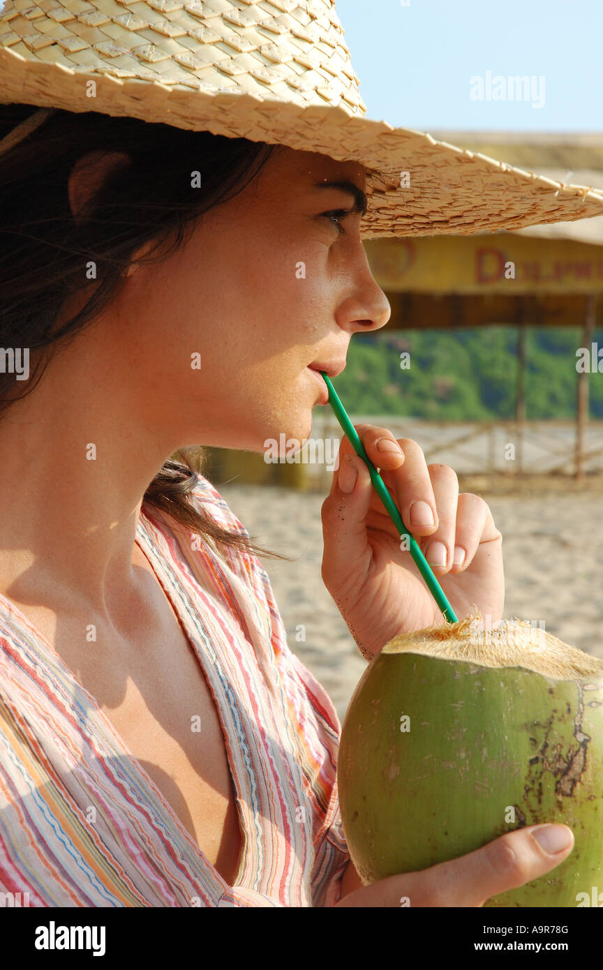 Portrait of a woman drinking coconut water Stock Photo - Alamy