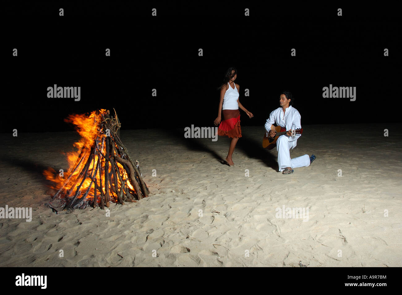 A young couple dancing by a bonfire Stock Photo - Alamy