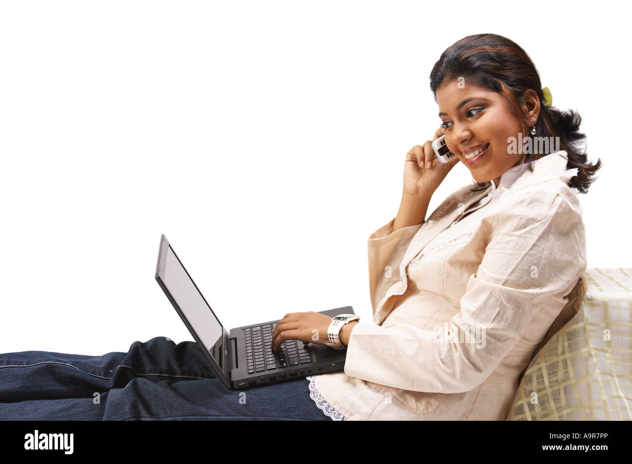 A woman working on laptop and speaking on cell phone Stock Photo - Alamy