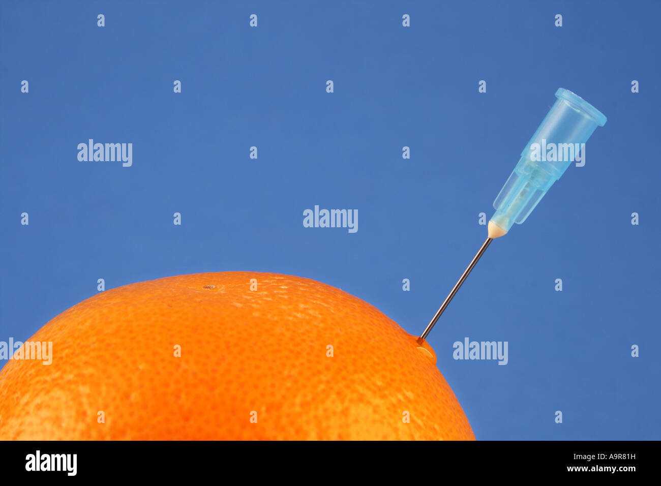 Syringe injecting orange Stock Photo - Alamy