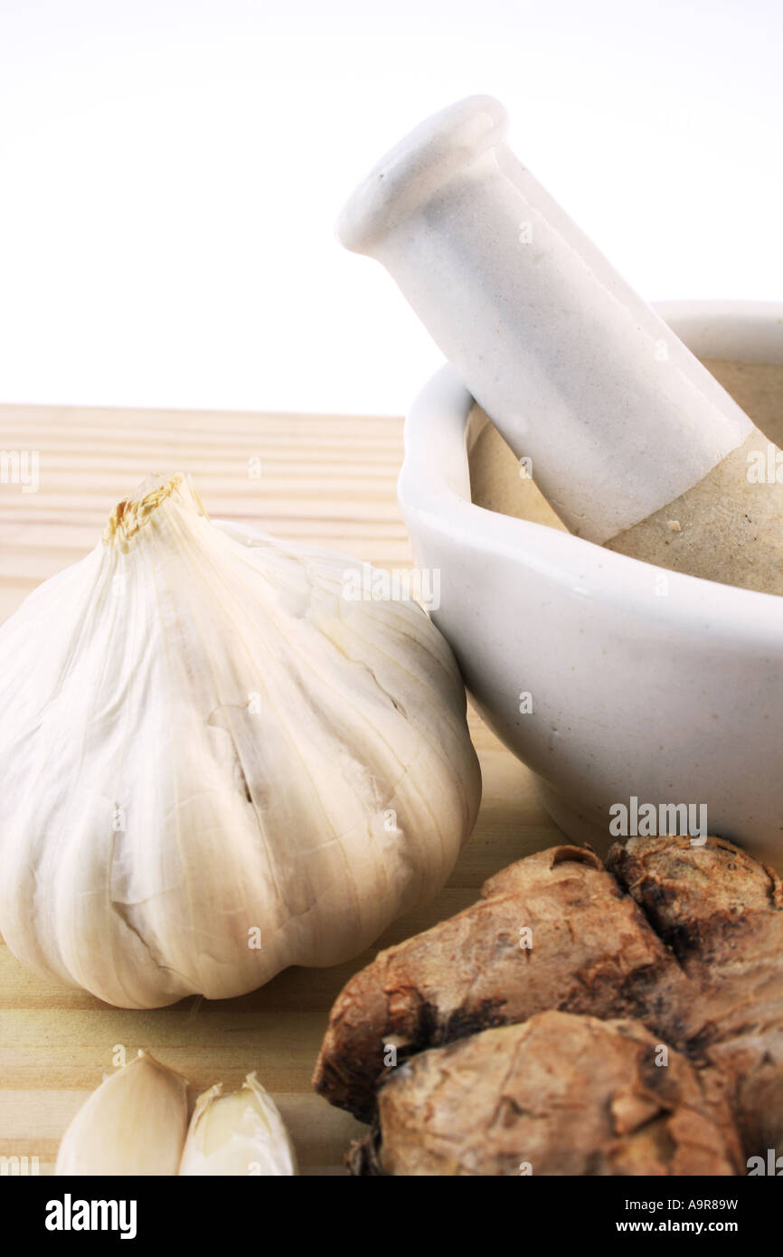 Ginger and garlic by a mortar with a pestle Stock Photo - Alamy