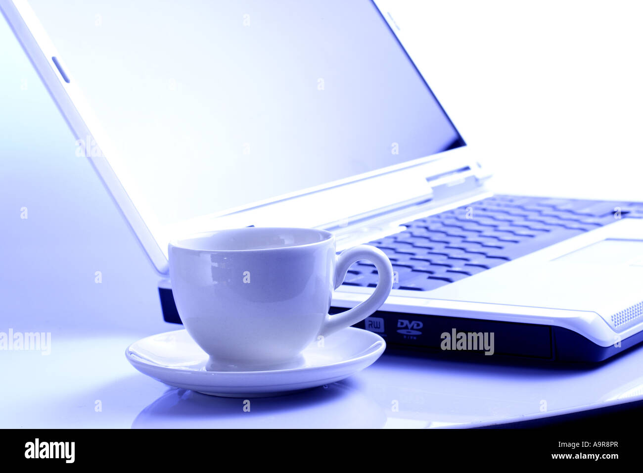 Partial view of a lap top with a cup Stock Photo - Alamy