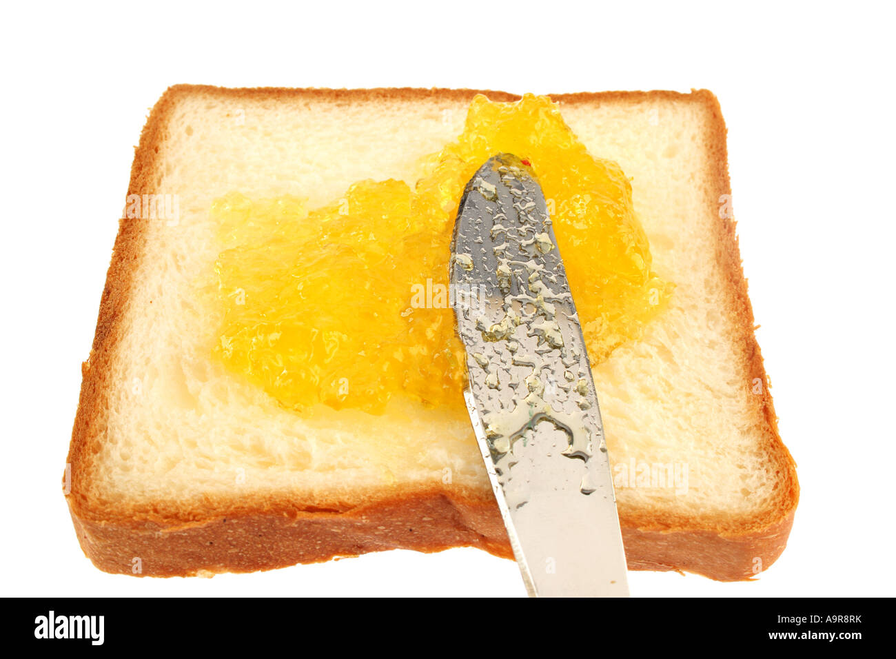 A knife being used to spread jam on a piece of bread Stock Photo - Alamy