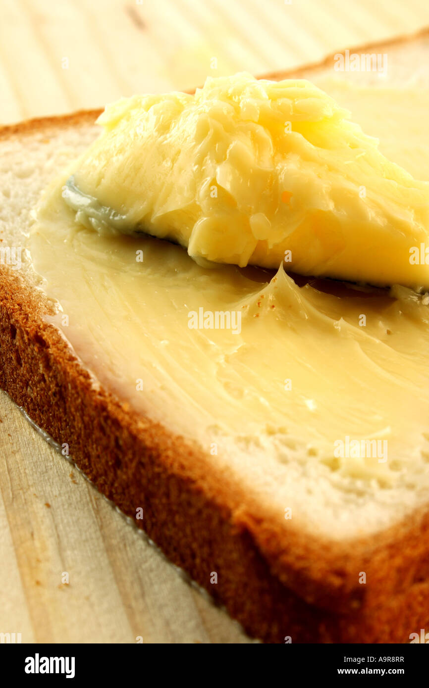 Butter spread on piece of bread Stock Photo - Alamy