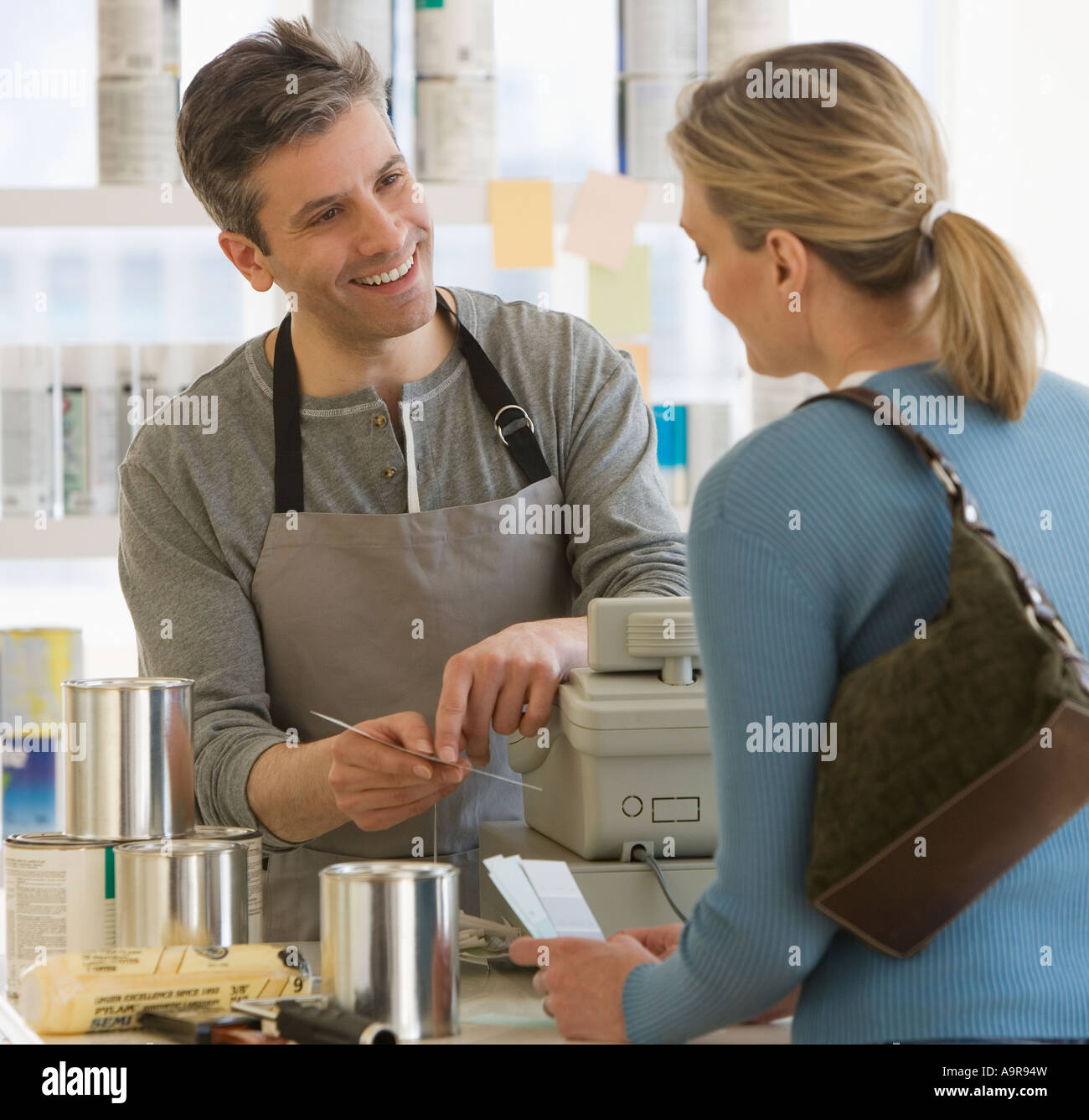 Woman talking to clerk at paint store Stock Photo - Alamy