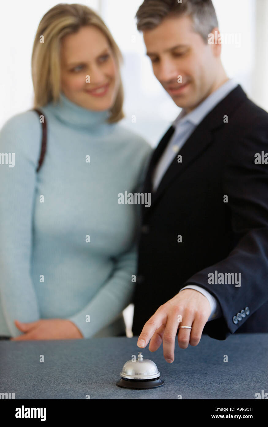Couple ringing bell at counter Stock Photo - Alamy