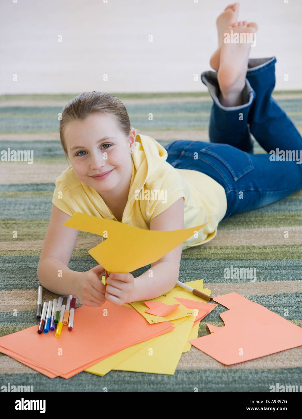 Girl cutting construction paper on floor Stock Photo - Alamy