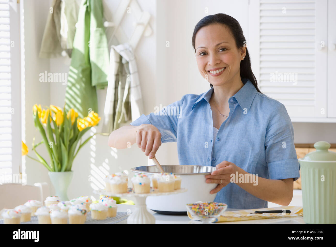 Asian woman stirring batter in kitchen Stock Photo - Alamy