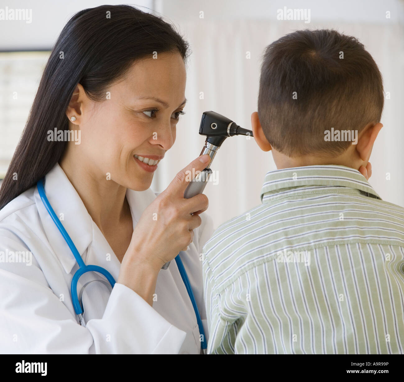 Asian female doctor examining boy s ear Stock Photo - Alamy