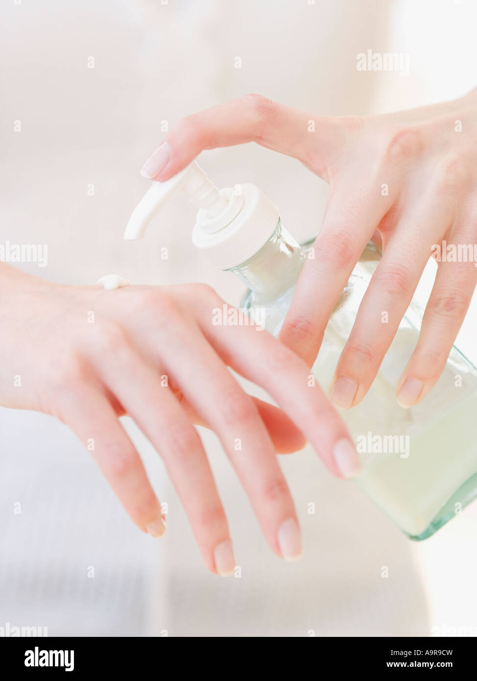 Woman applying hand lotion Stock Photo - Alamy