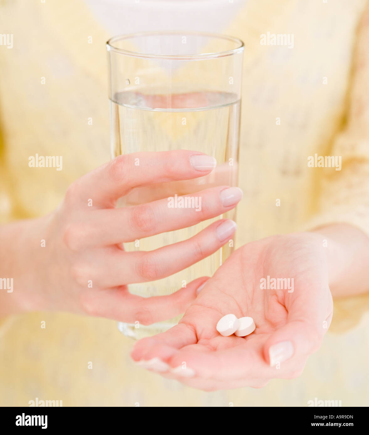 Woman holding water and medication Stock Photo - Alamy