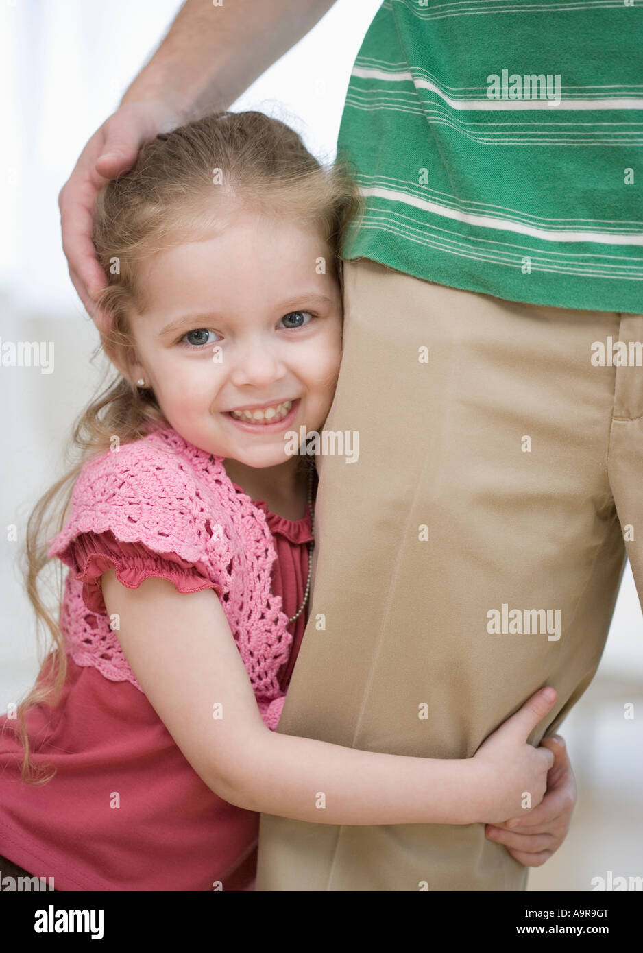 Girl hugging father s leg Stock Photo - Alamy